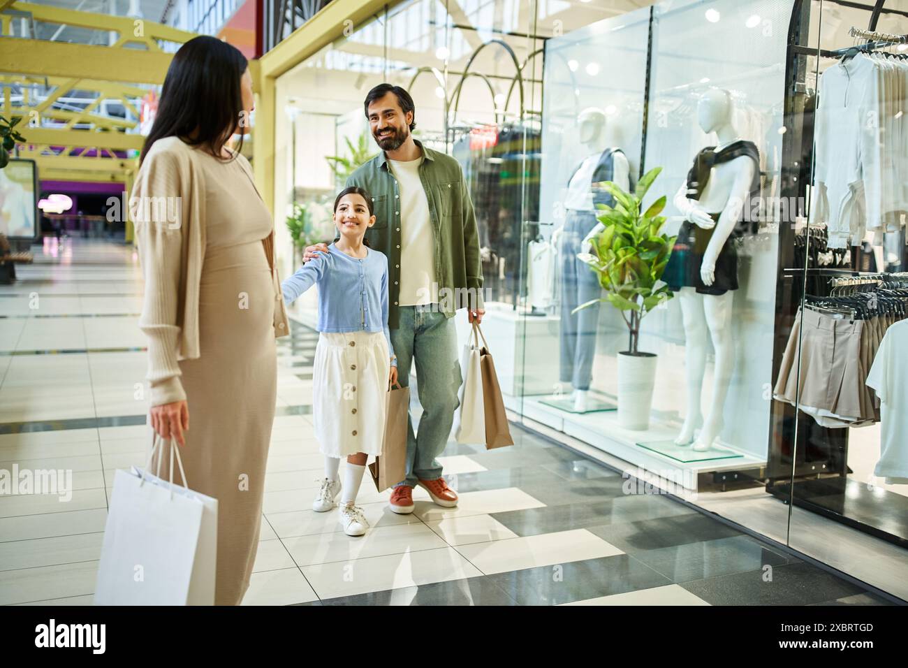 A man and woman shopping together with kid in a vibrant mall, browsing ...