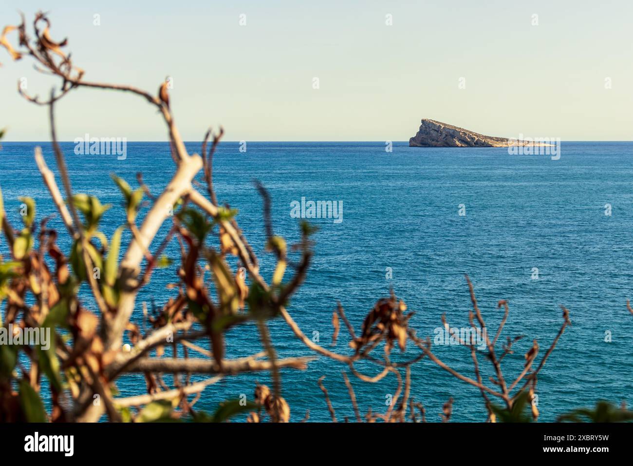 The image presents a serene seascape view featuring the small island ...