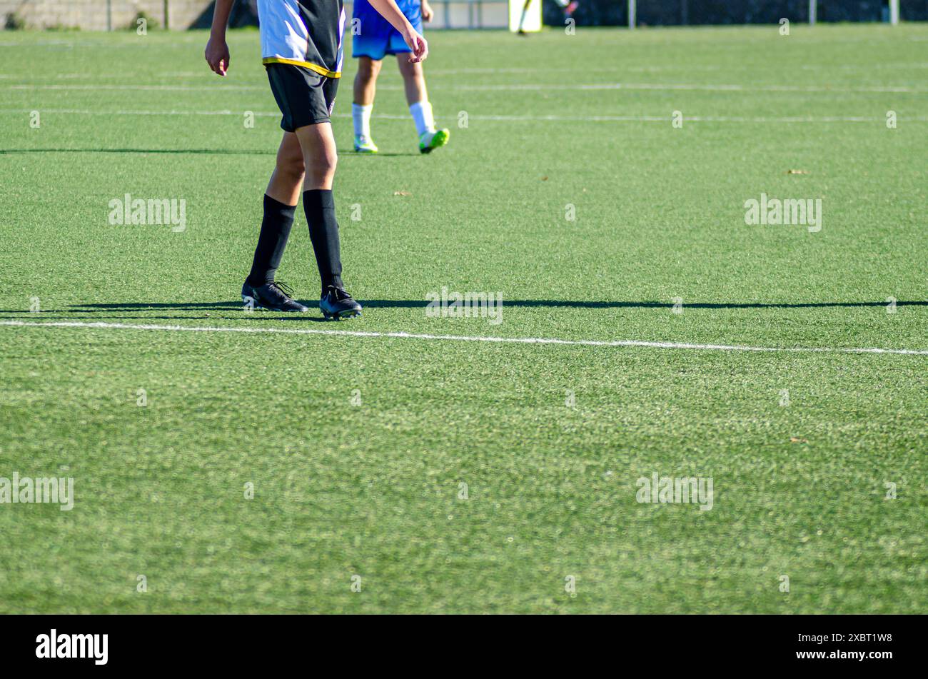 view of the legs of two soccer players on an artificial turf soccer ...