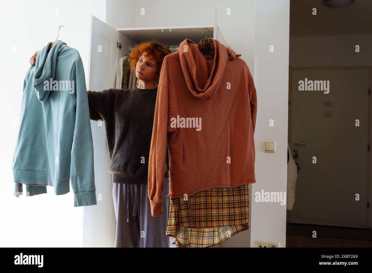 Teenager girl looking at clothes in wardrobe Stock Photo - Alamy