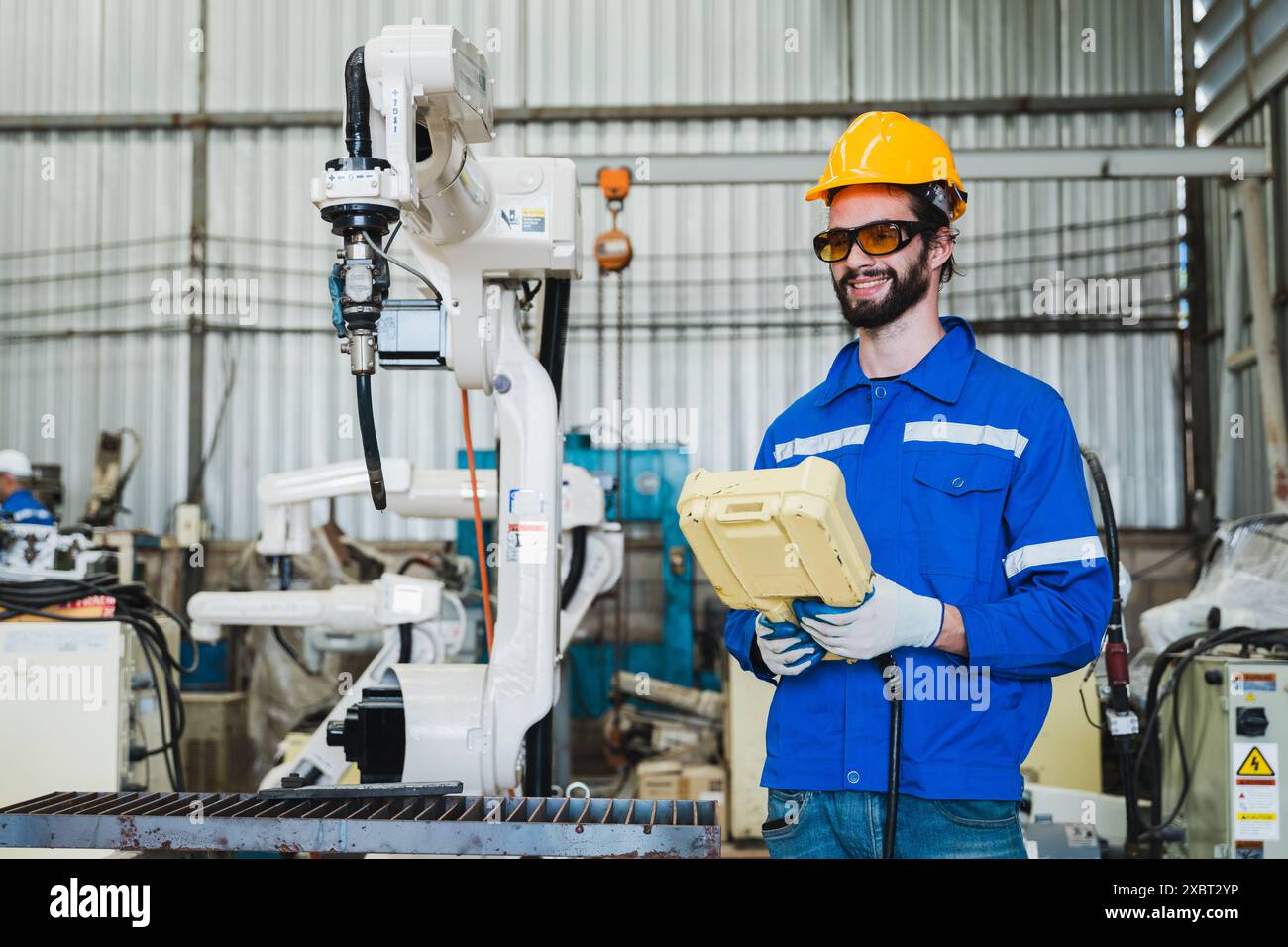 engineer controlling robot arm at factory. checking the operation of robot arm. Technology ...