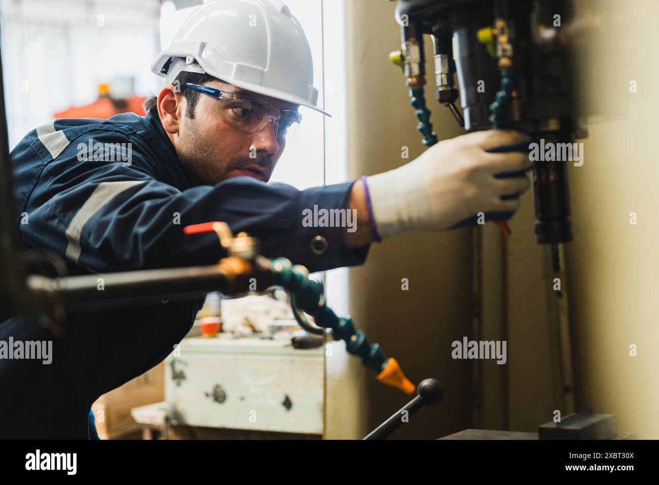 A mechanic is inspecting the oil level in the engine of a machine in a ...