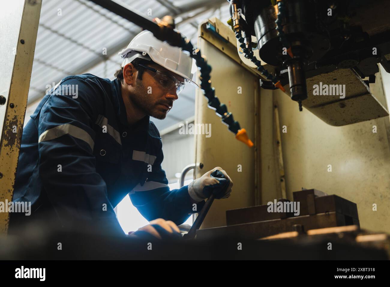 A mechanic is inspecting the oil level in the engine of a machine in a ...