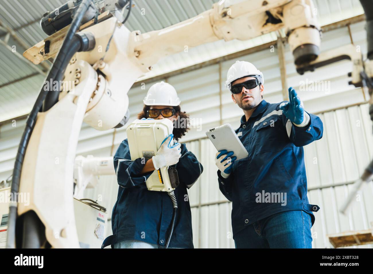 Engineer Controlling Robot Arm At Factory Checking The Operation Of Robot Arm Technology