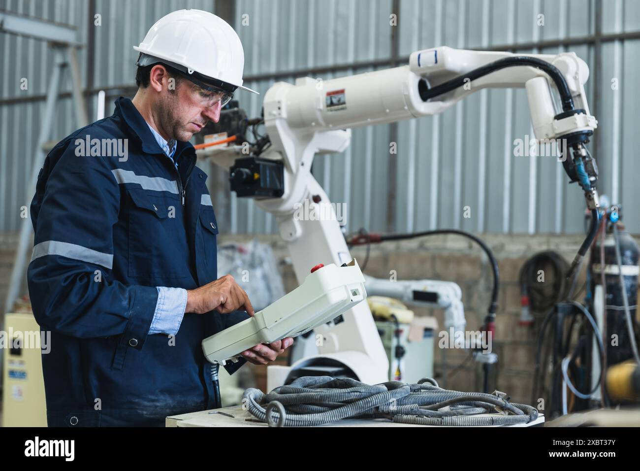 Engineer Controlling Robot Arm At Factory Checking The Operation Of Robot Arm Technology