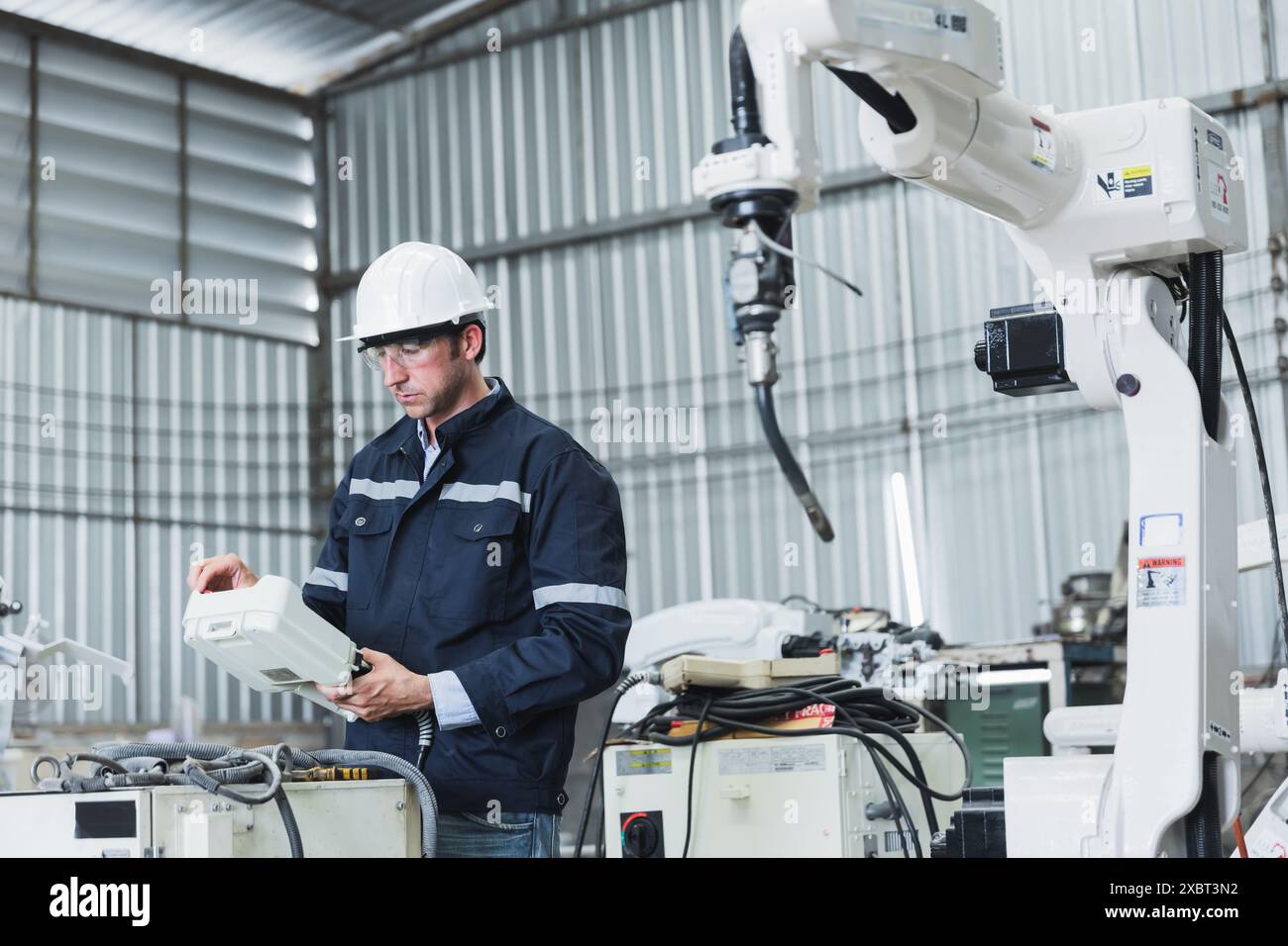 Engineer Controlling Robot Arm At Factory Checking The Operation Of Robot Arm Technology