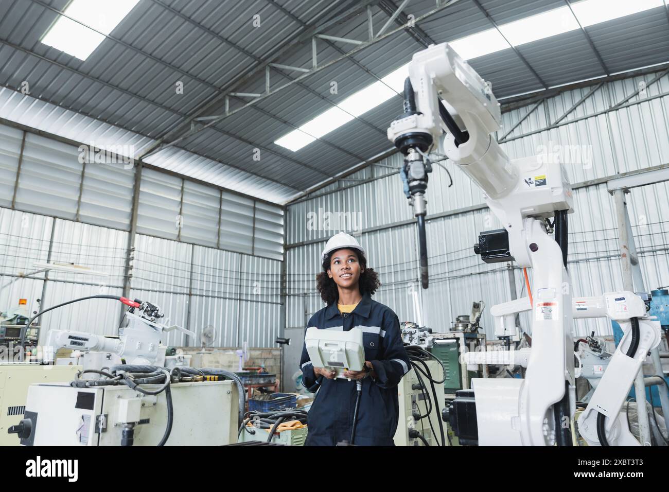 engineer controlling robot arm at factory. checking the operation of ...