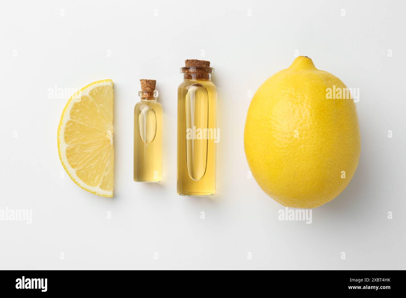 Bottles of essential oils and lemon on white background, top view Stock ...