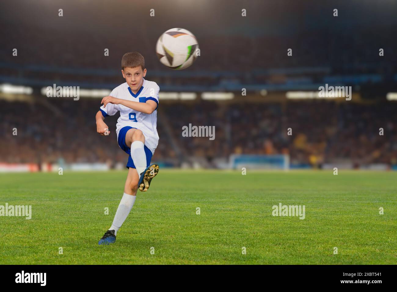 Young boy kicks the ball with determination at the final of the world ...