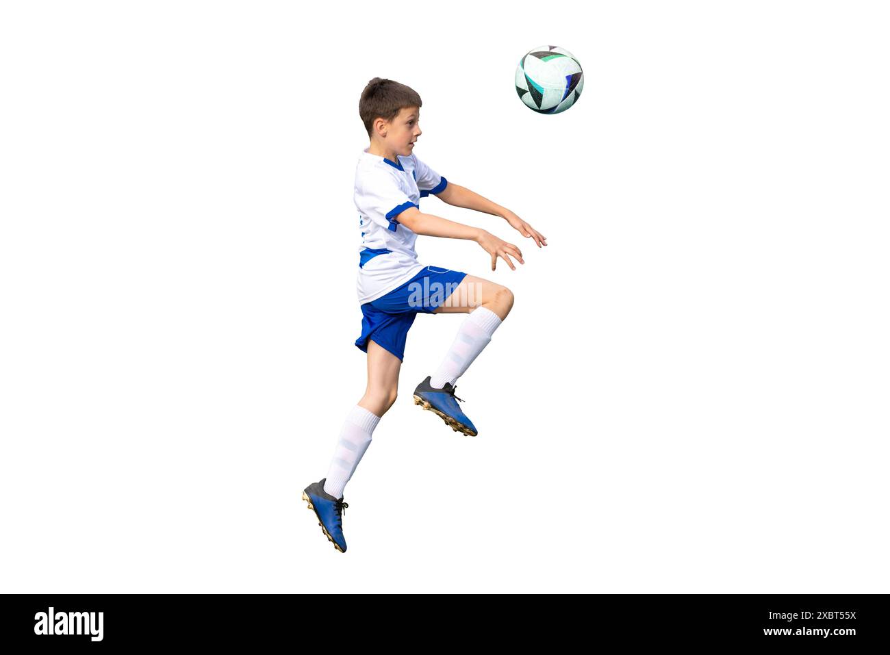 Isolated young soccer player leaps into the air, using his head to ...