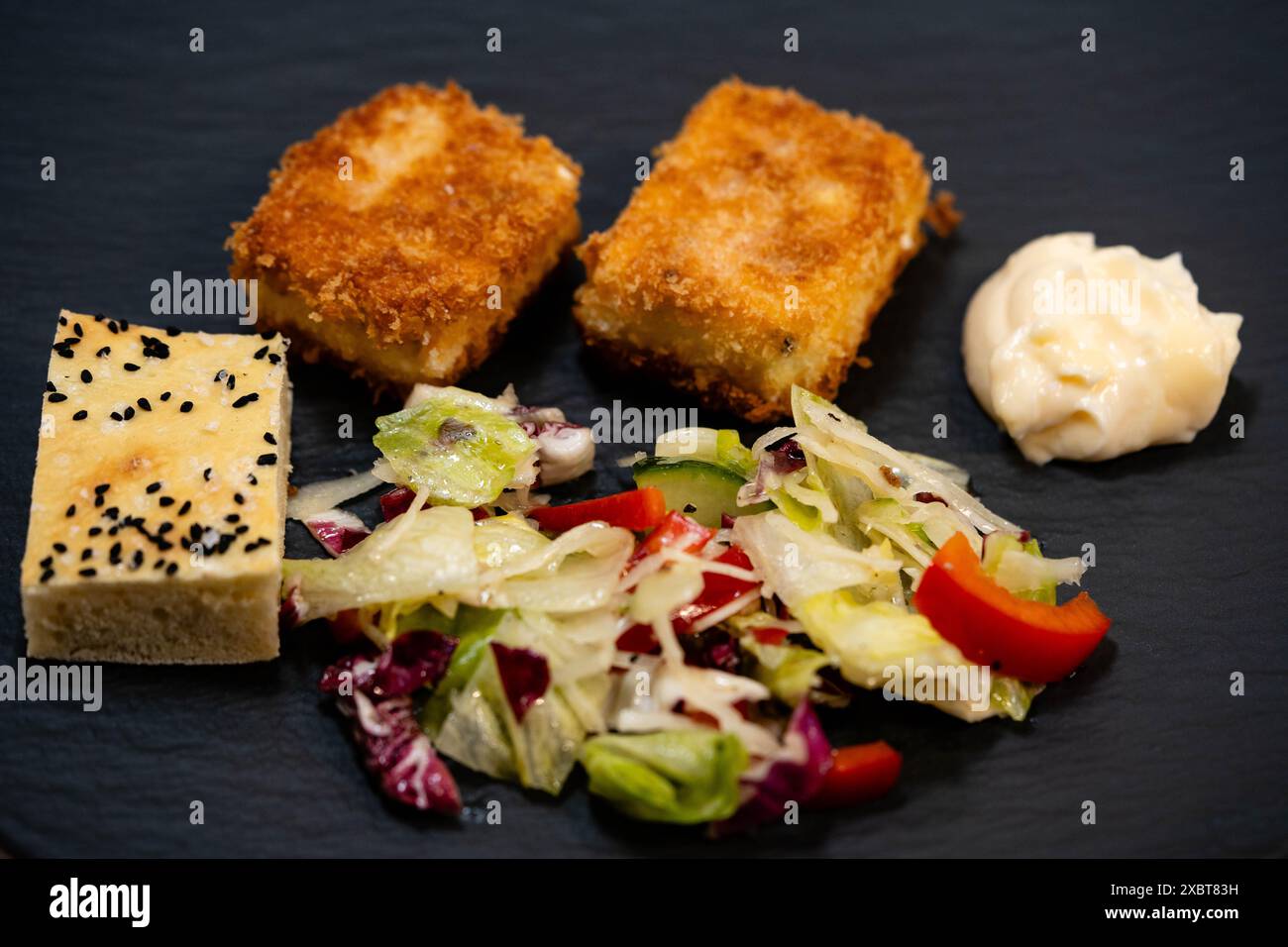 breaded and baked greek sheep's cheese with herbs and spices Stock ...