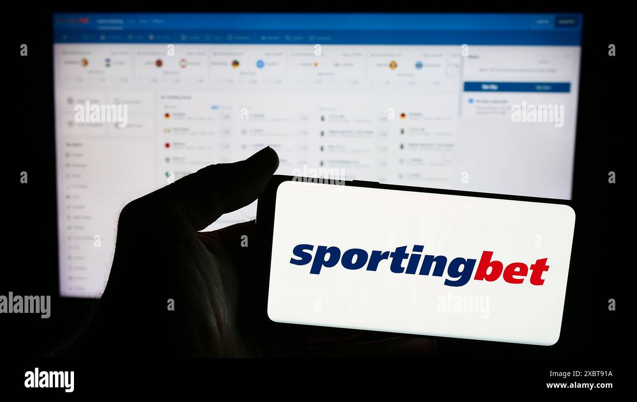 Person holding mobile phone with logo of British sports betting company ...