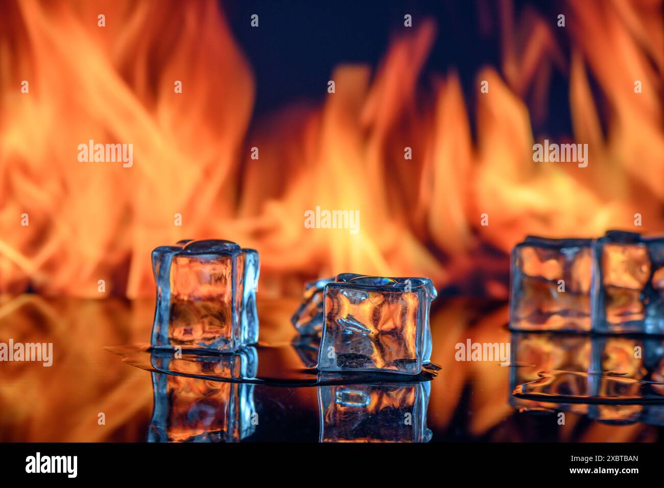 cubes of ice and fire on a water surface on an abstract background ...