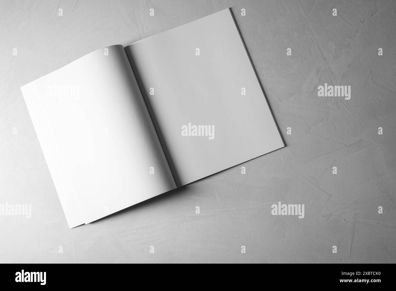 Open notebook with blank paper sheets on grey textured background, top ...