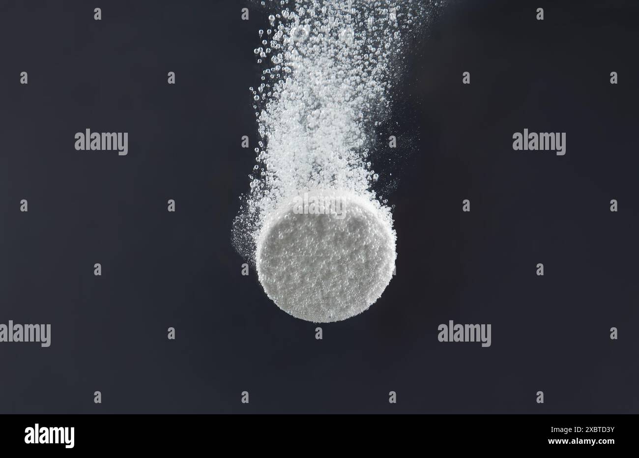 Effervescent pill dissolving in water on dark background, closeup Stock ...