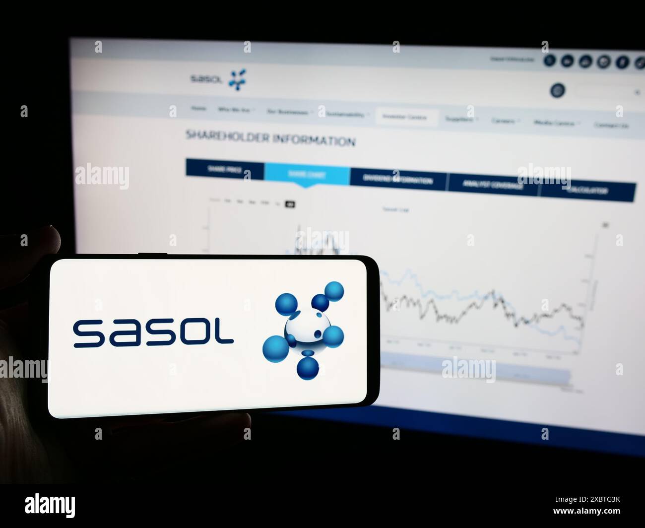 Person holding mobile phone with logo of South African energy company ...