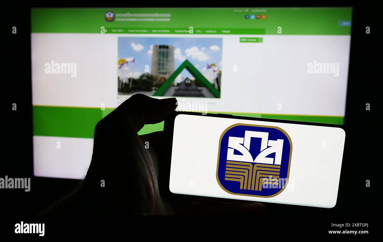 Person holding mobile phone with logo of Bank for Agriculture and ...