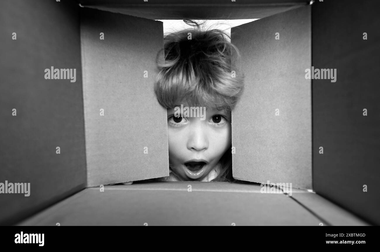 Excited cute child opening a present. Cardboard boxes, parcels ...