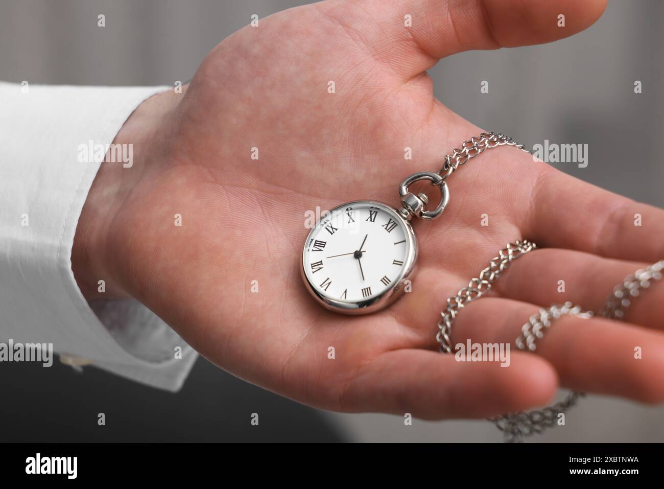 Hand holding watch on chain hi-res stock photography and images - Alamy