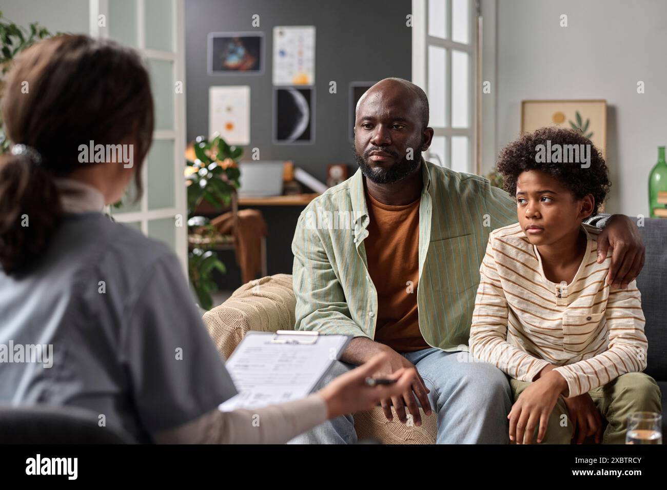 Portrait of African American father and son listening to psychologist ...