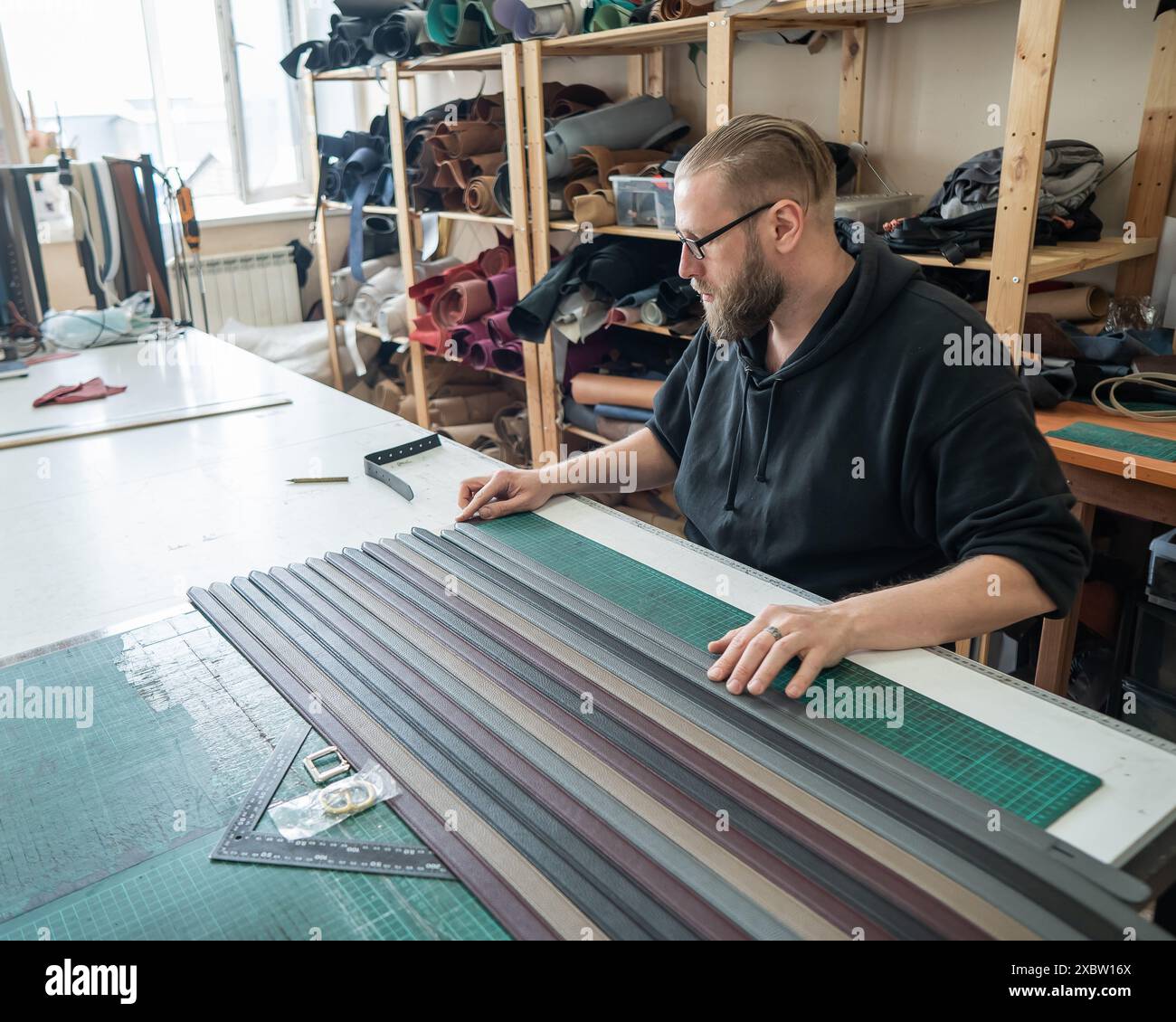 Leatherworker making leather belts in workshop Stock Photo - Alamy