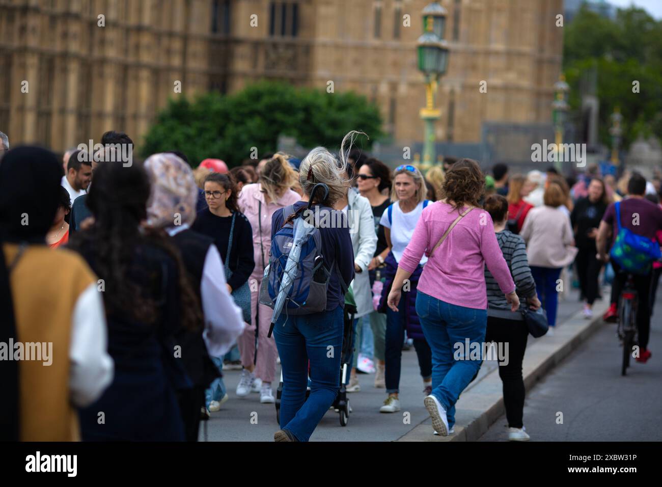 People brave strong winds as they cross Westminster Bridge in London ...