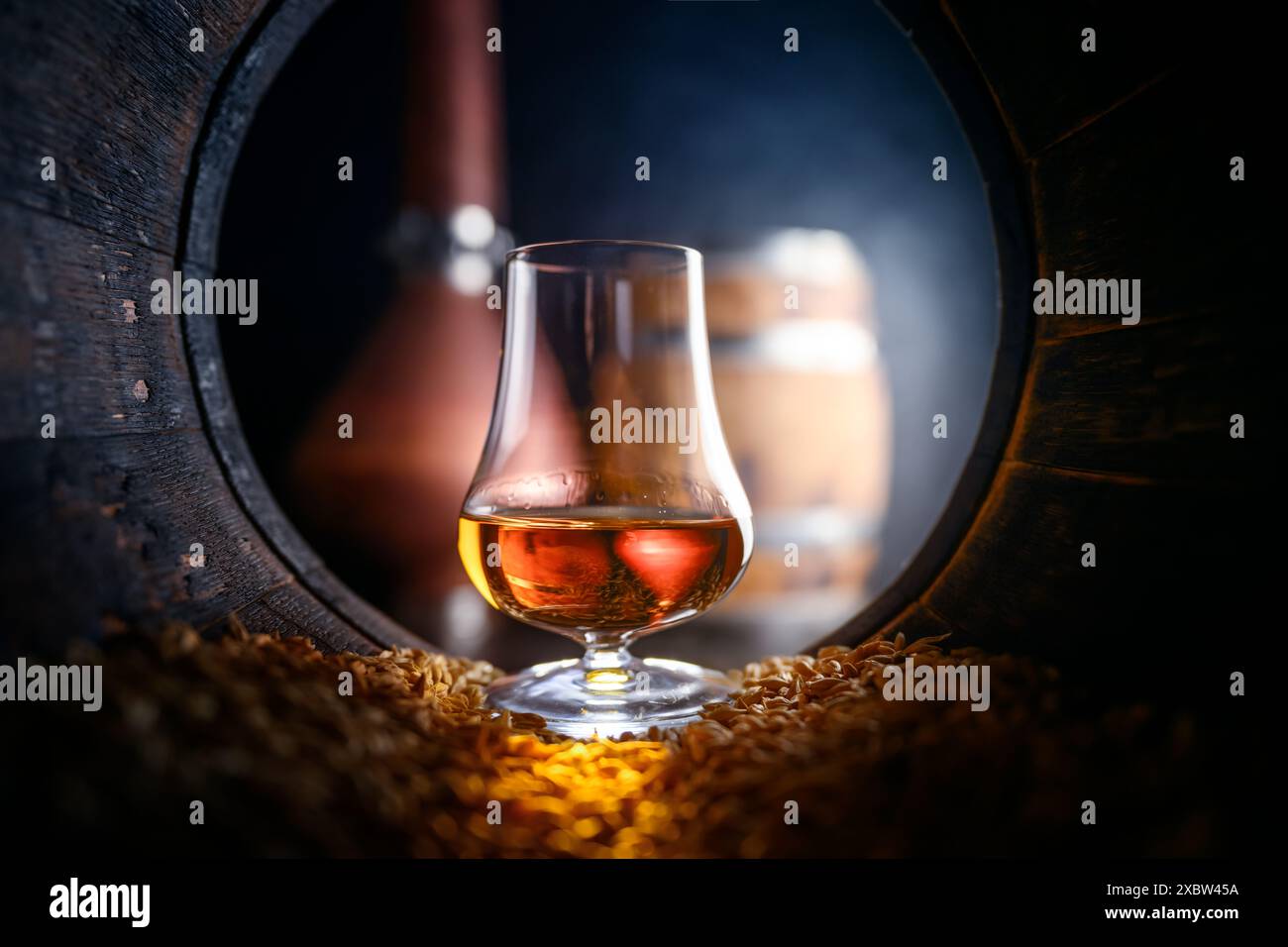 Tasting glass with whiskey standing inside of old oak barrel filled ...