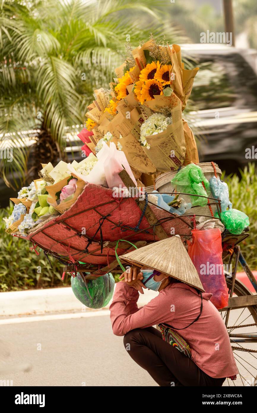 Traditional Hanoi Old Town flower entrepreneur, looking away from ...