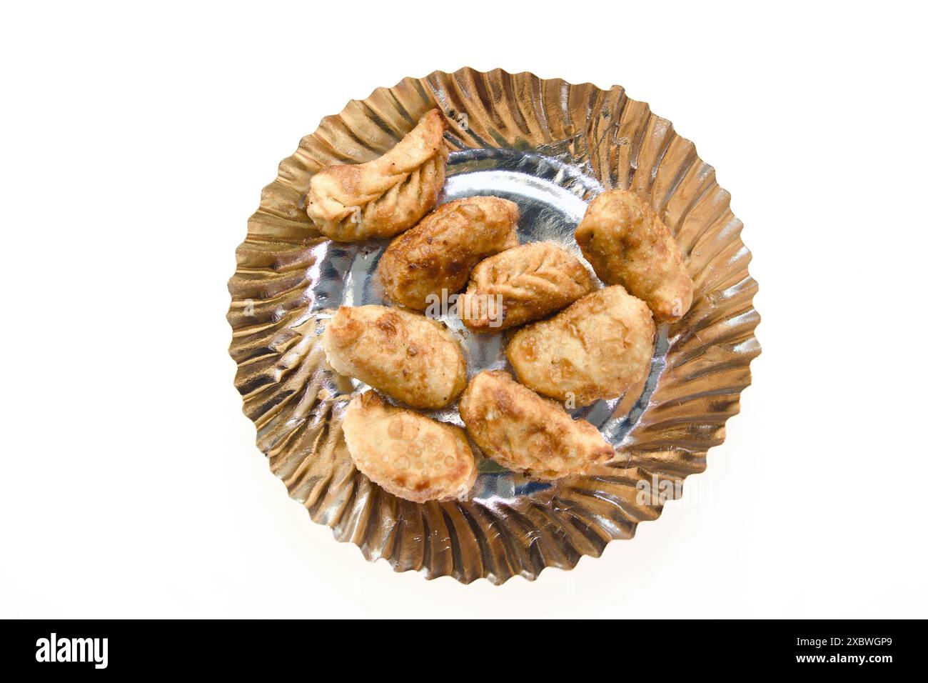 Delicious golden-brown fried momos served on an white backdrop ...