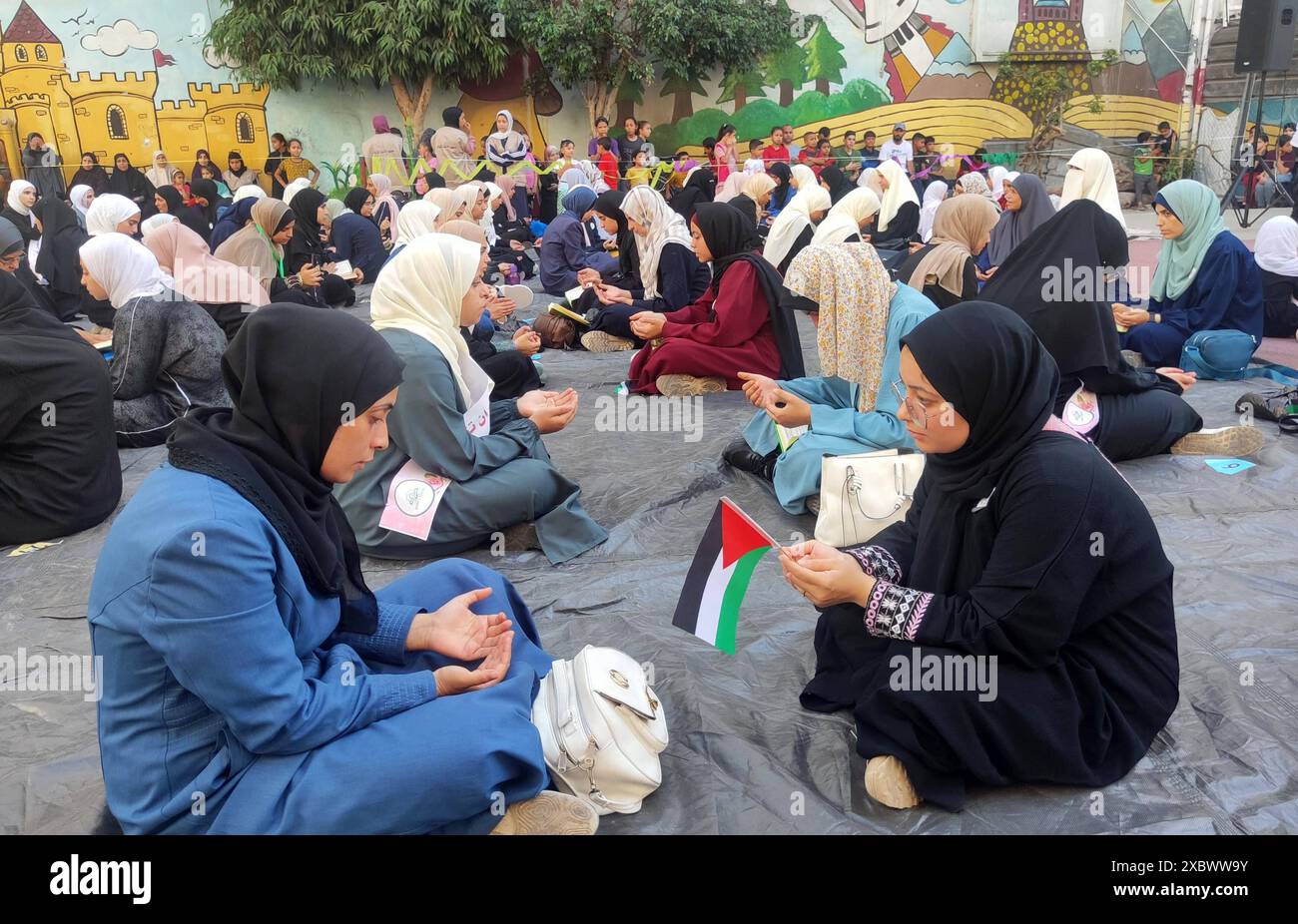 Women and girls assist each other to recite verses from the Koran ...