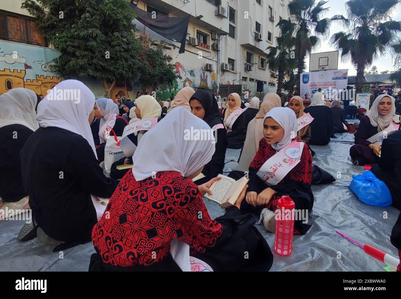 Women and girls assist each other to recite verses from the Koran ...