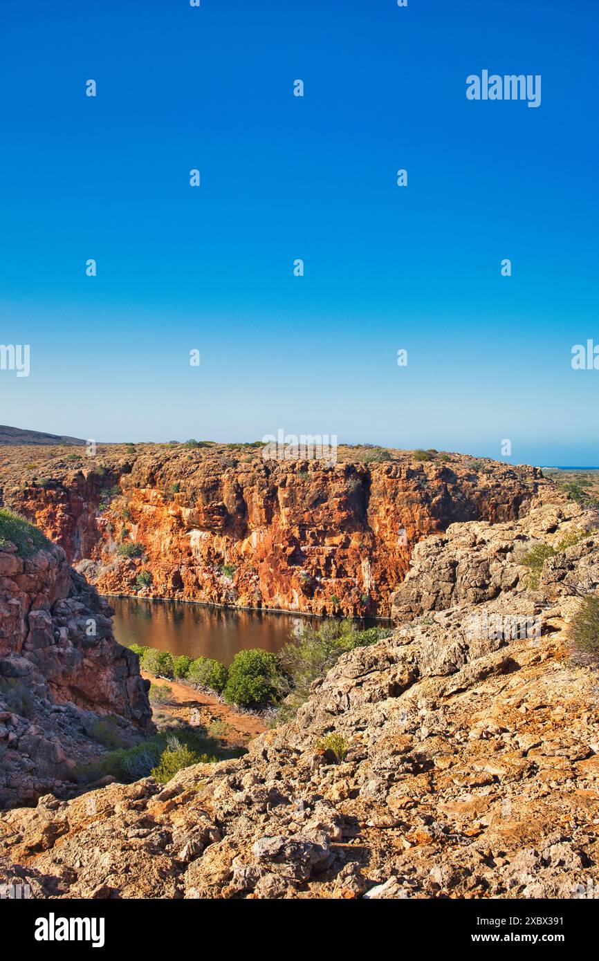 Heavily eroded red limestone rocks at the gorge of the Yardie Creek in ...
