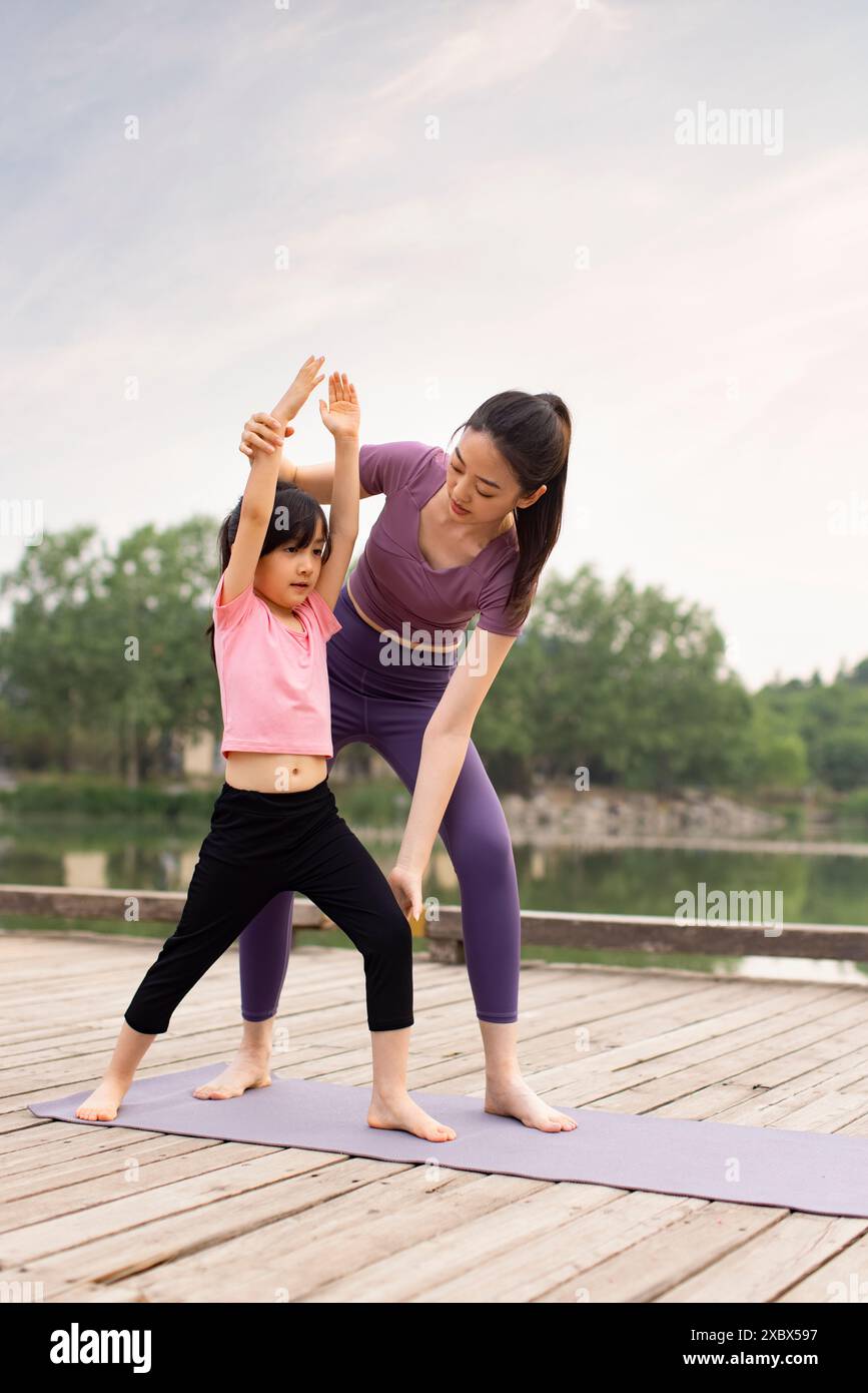 Mom And Daughter Doing Yoga In A Park Stock Photo - Alamy