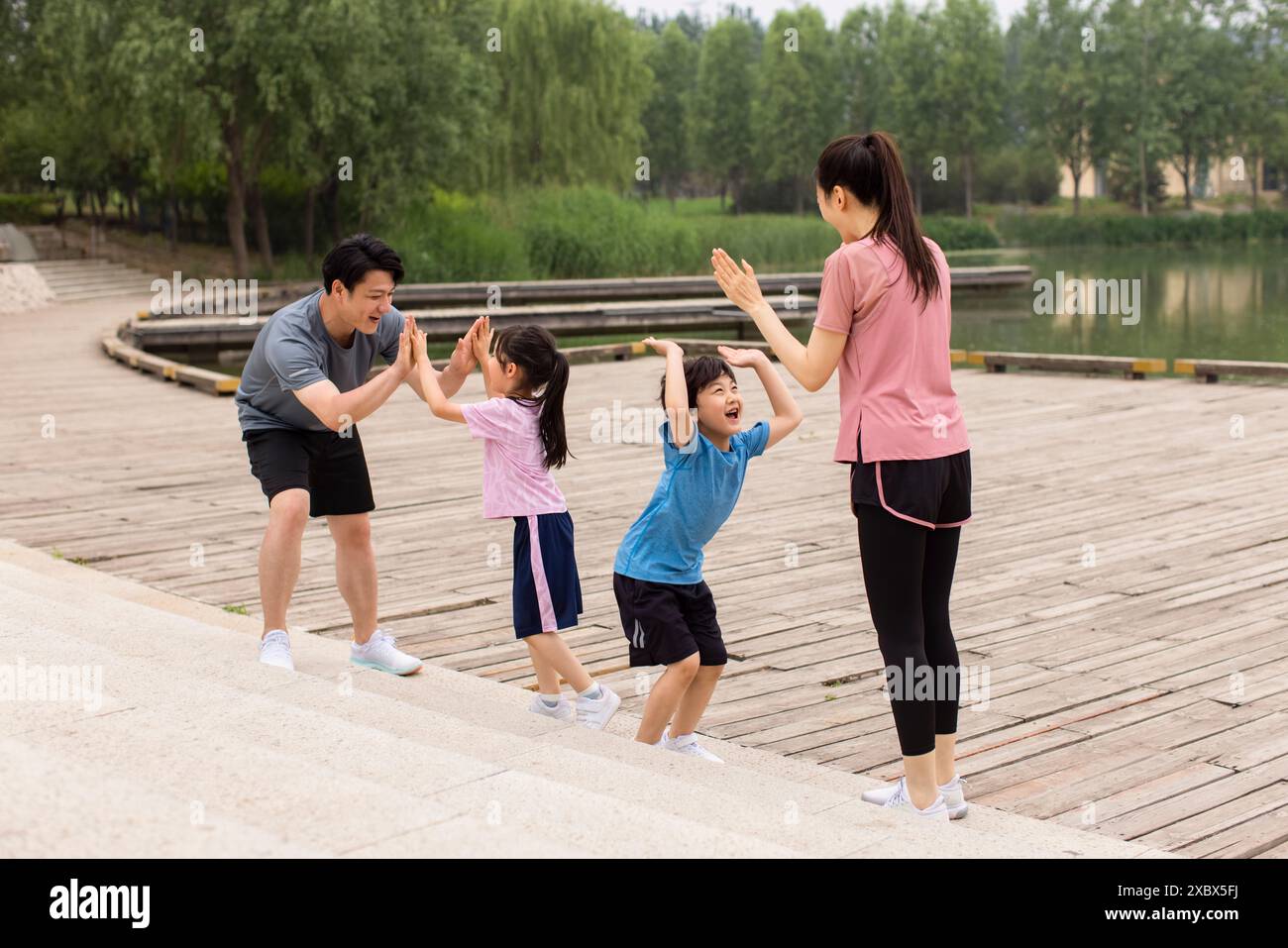 Parents And Kids Exercising In A Park Stock Photo - Alamy
