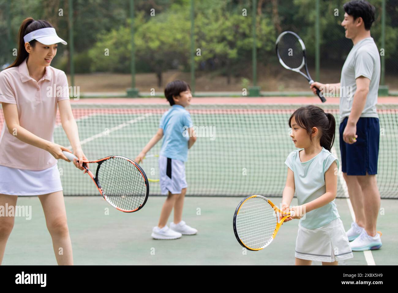 Family Playing Tennis On The Tennis Court Stock Photo - Alamy