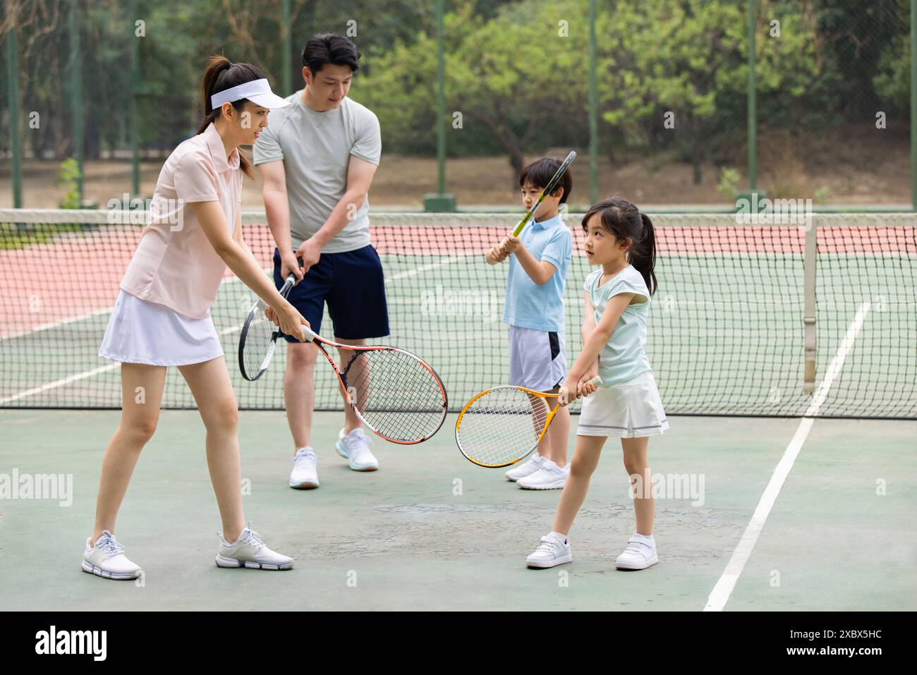 Family Playing Tennis On The Tennis Court Stock Photo - Alamy