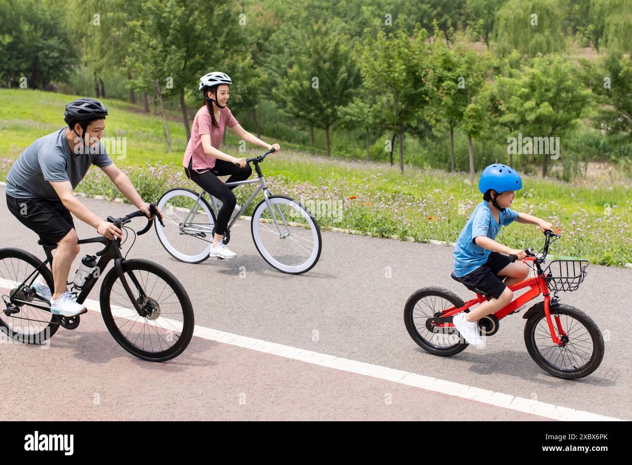 Chinese Family Riding Bicycles In A Park Stock Photo - Alamy