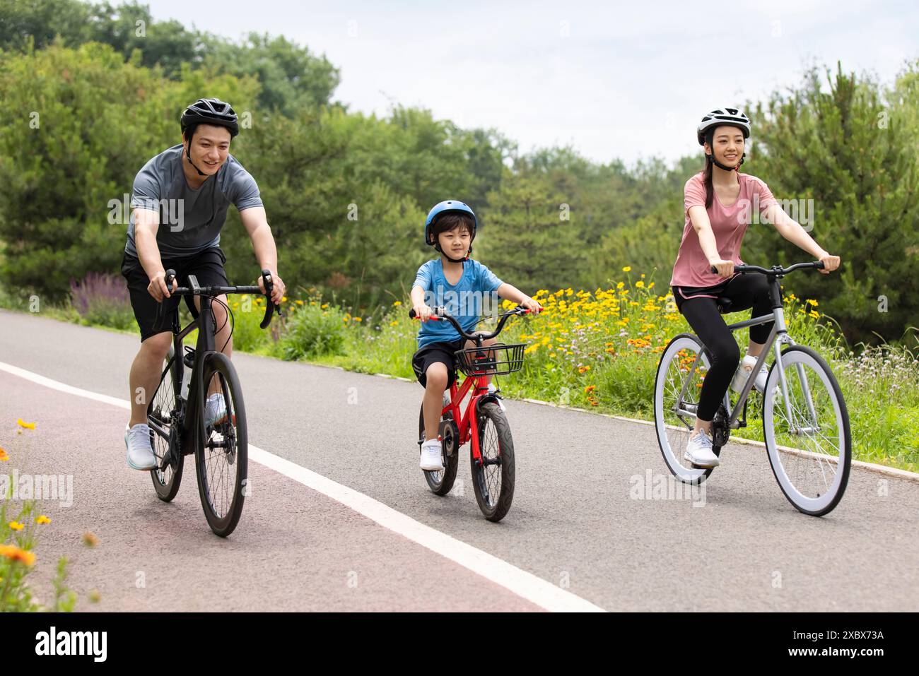 Chinese Family Riding Bicycles In A Park Stock Photo - Alamy