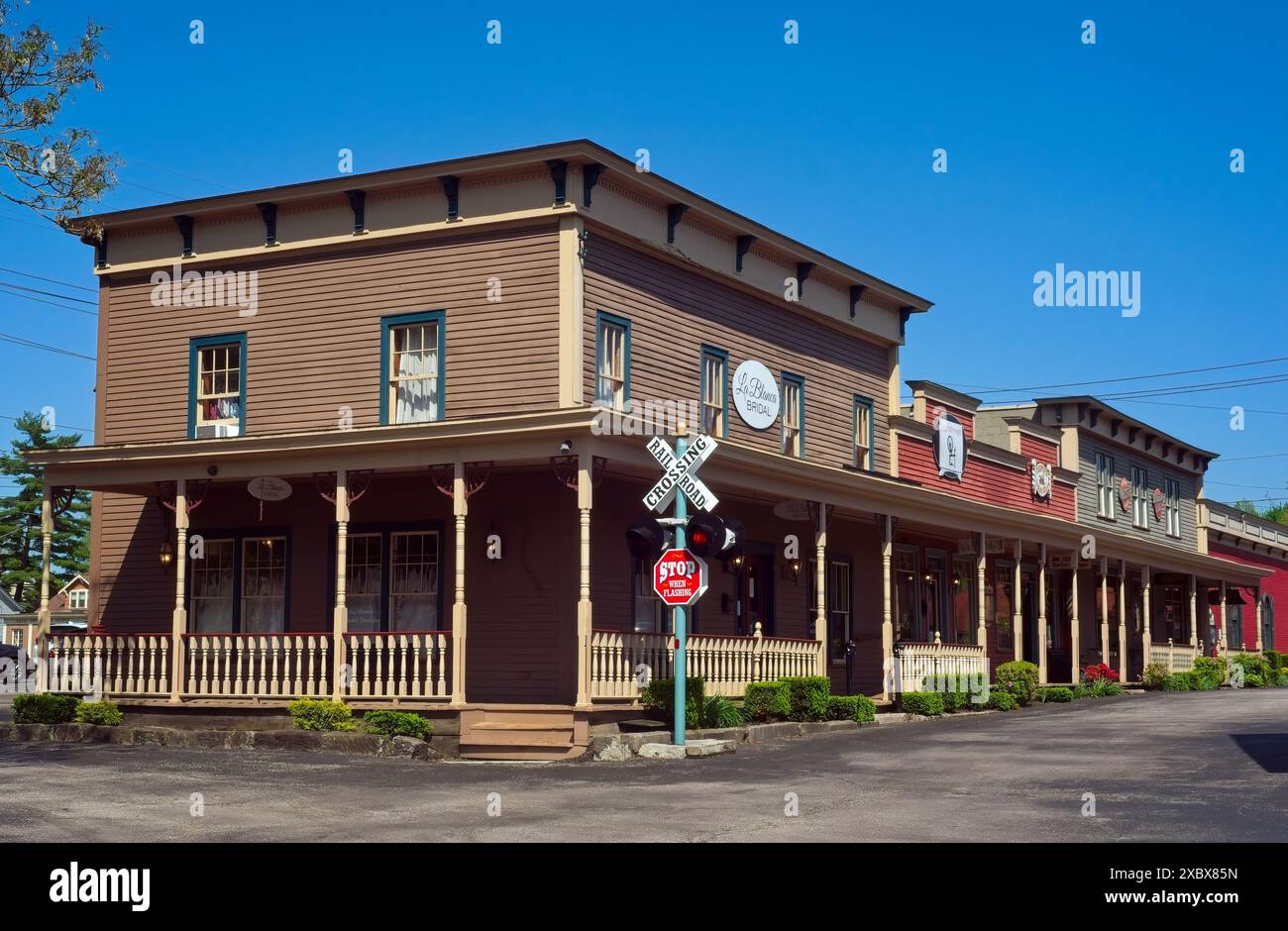 A block of vintage shops with a covered walkway and a railroad crossing ...