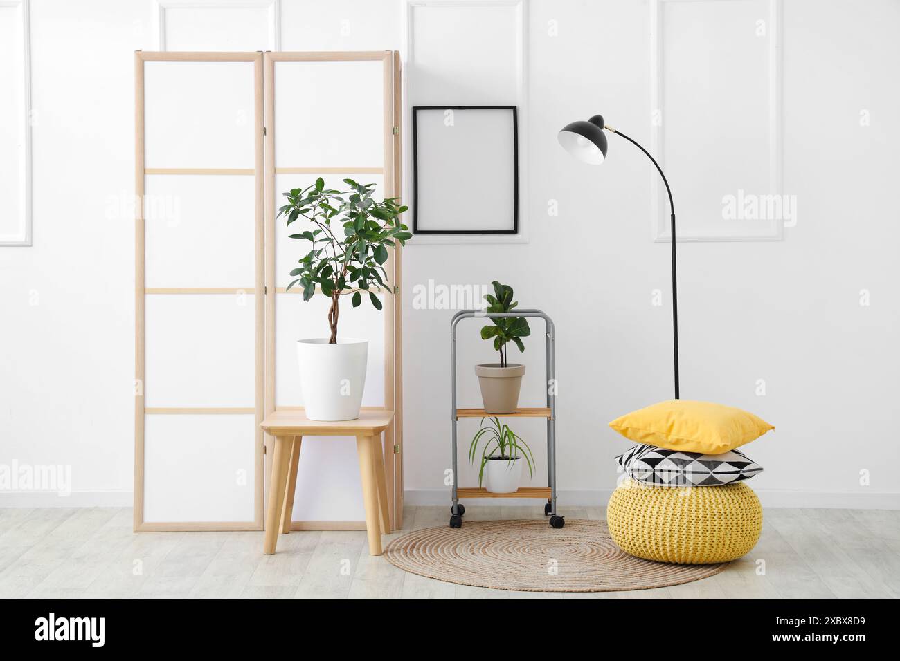 Interior of room with stylish folding screen, shelving unit and ...