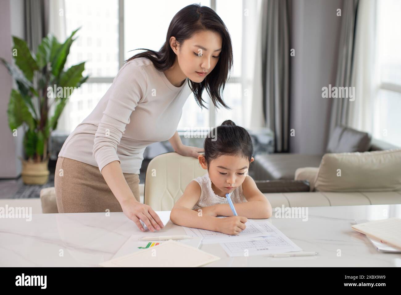 Mum Helping Daughter With Her Homework Stock Photo - Alamy