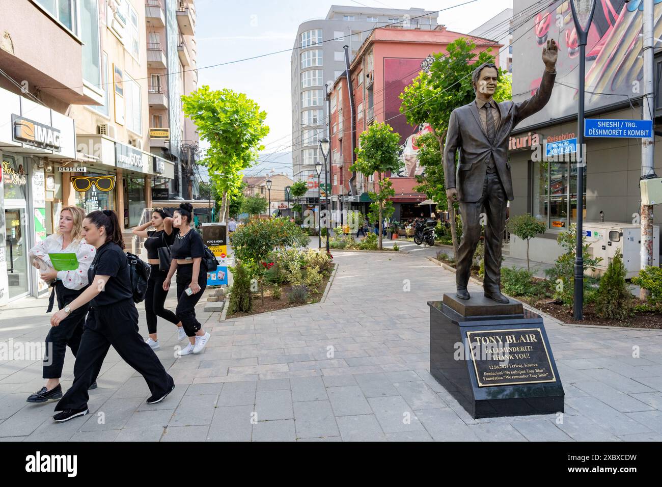 People walk by the statue of former British PM Sir Tony Blair in 'Tony Blair Square' in Kosovo's ...