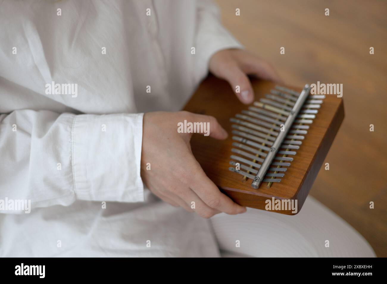Kalimba in the hands of a young woman musician in white clothes Stock ...