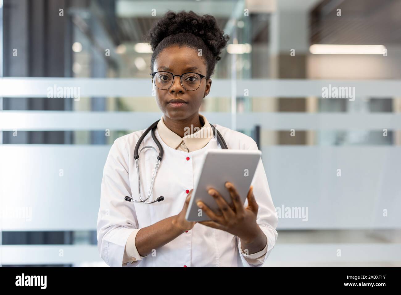 Confident female doctor using a digital tablet in a modern hospital ...