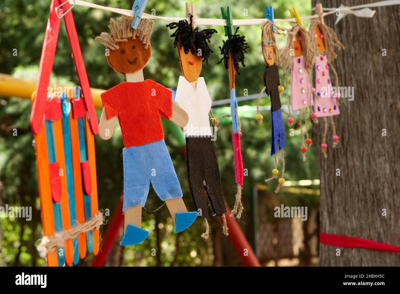 Handmade popsicle stick dolls with unique features and clothing hang on ...