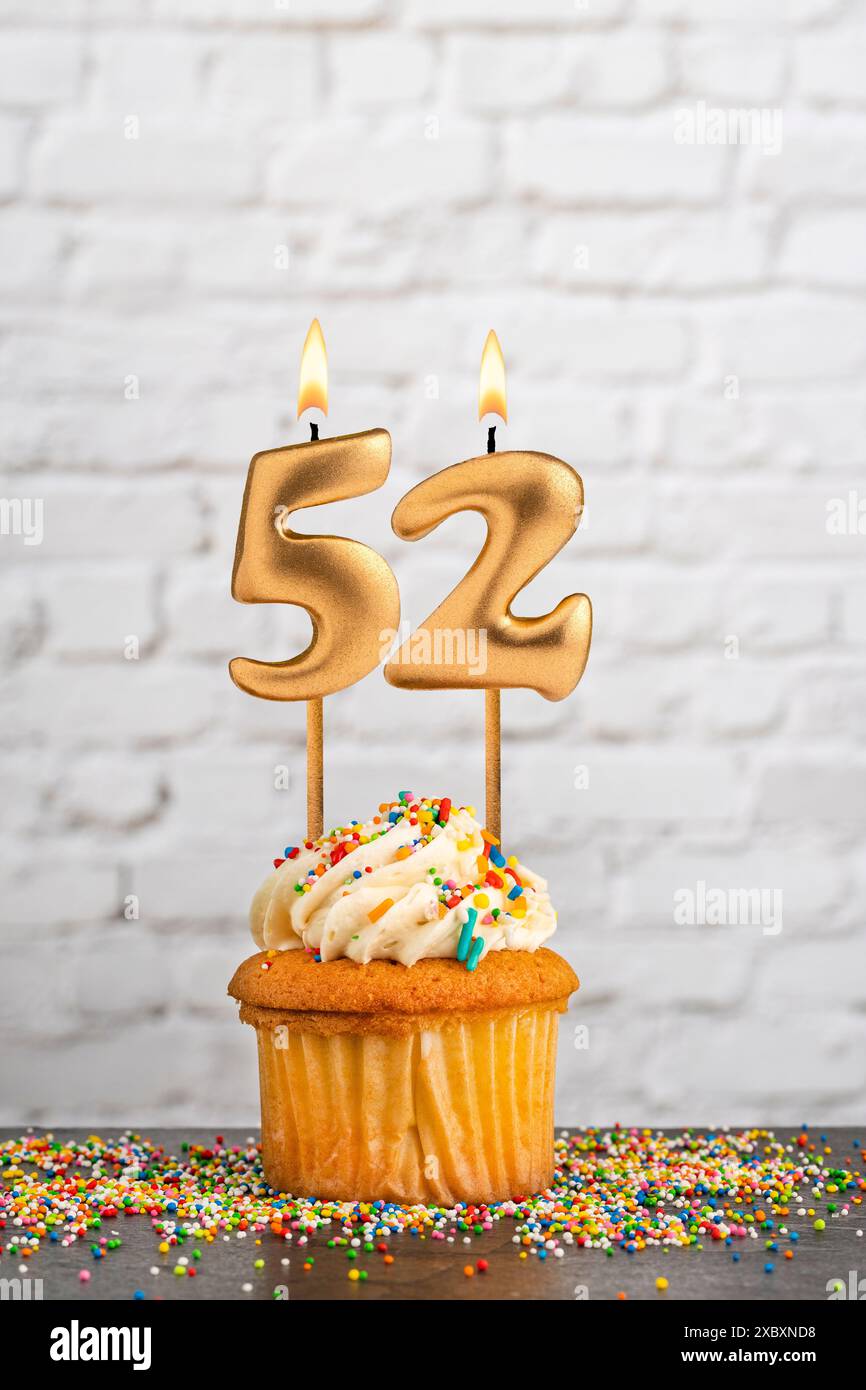 Cupcake with number 52 birthday candle - White block wall background ...