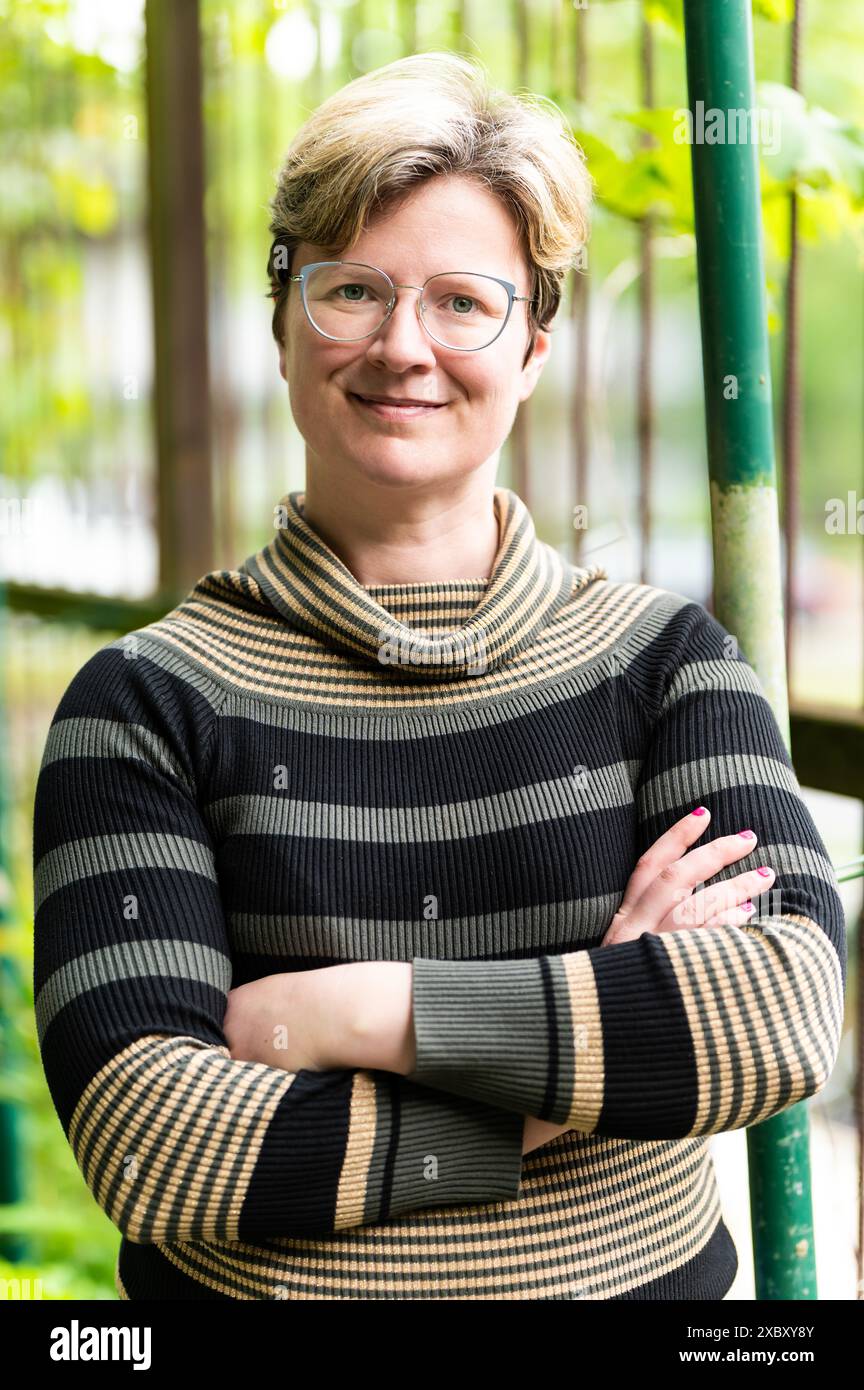 Portrait of a 38 yo white woman outdoors with a green grid background ...