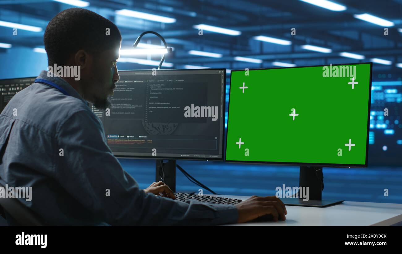 Employee working on green screen computer in server hub capable of ... Employee working on green screen computer in server hub capable of ...
