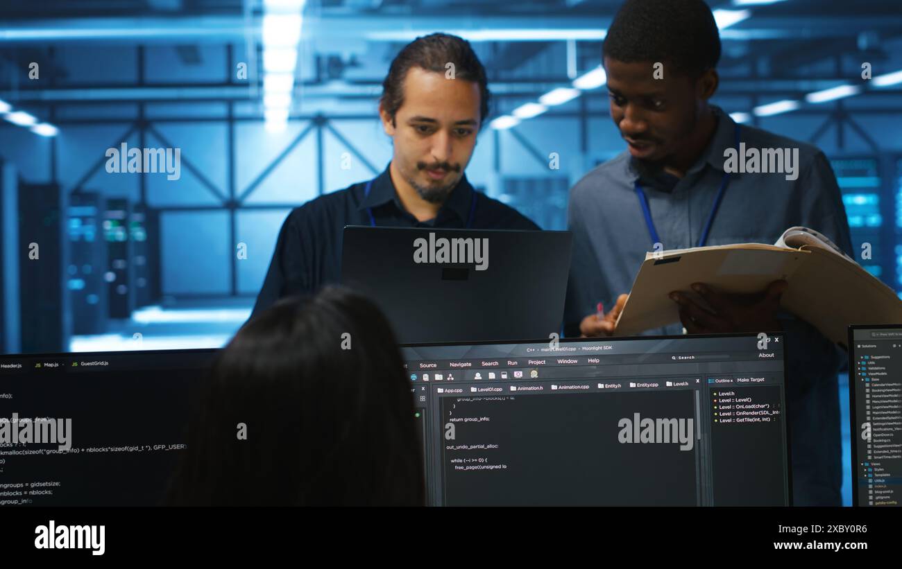 Man Inspecting Server Hub Infrastructure Reading Paperwork From Folder