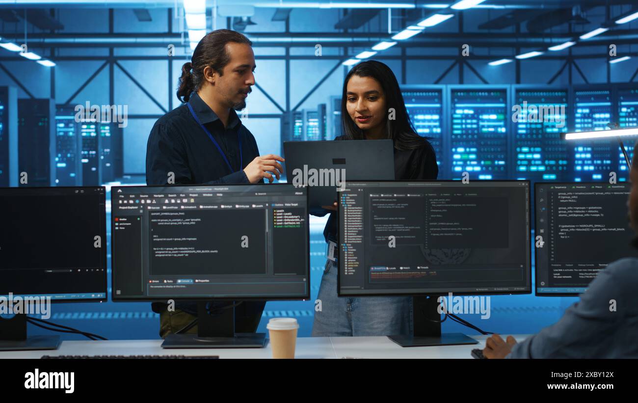Programmer and supervisor in server room looking for equipment misconfigurations, doing ...